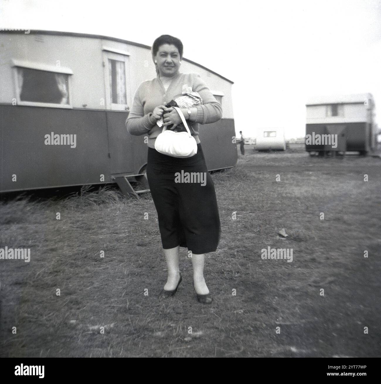 1950s, historical, a lady in a long skirt and holding her handbag ...