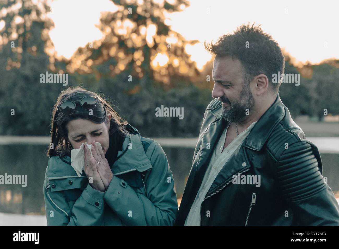 Sad crying woman blowing her nose in a tissue, man trying to comfort ...