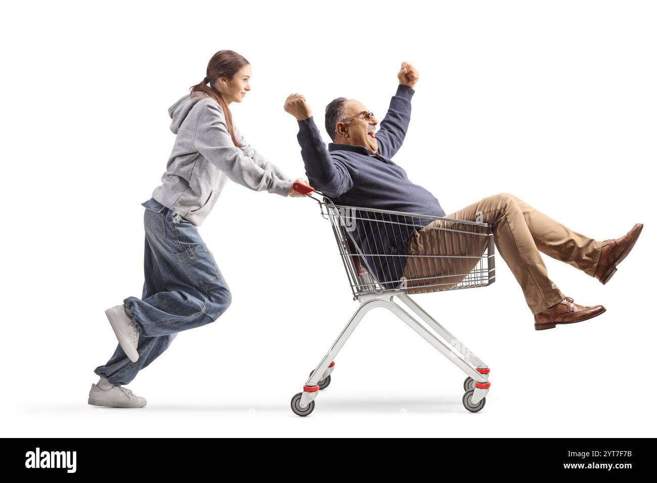 Female teenager pushing a mature man seated in a shopping cart isolated ...
