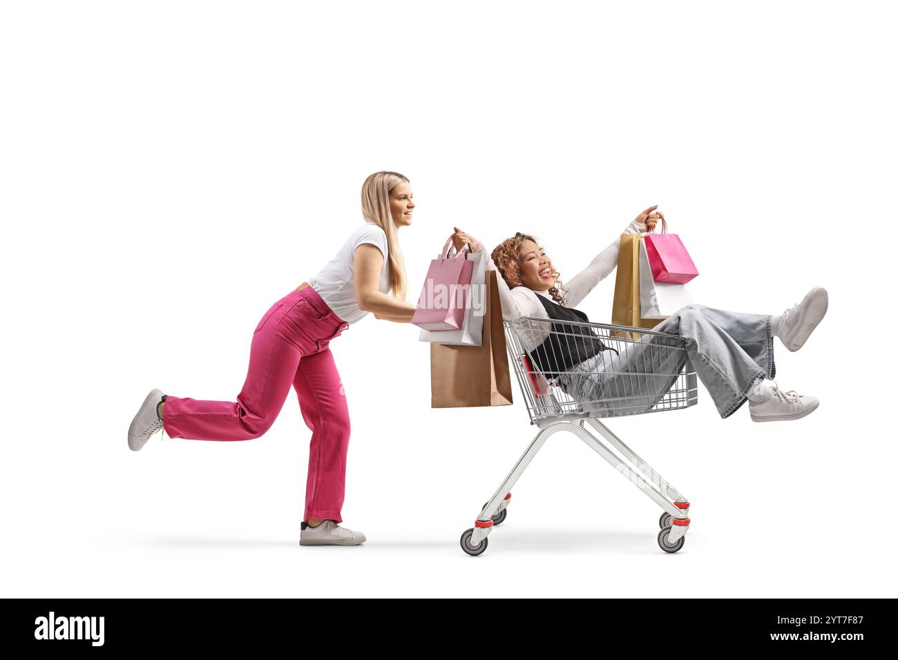 Girls having fun with a shopping cart isolated on white background ...
