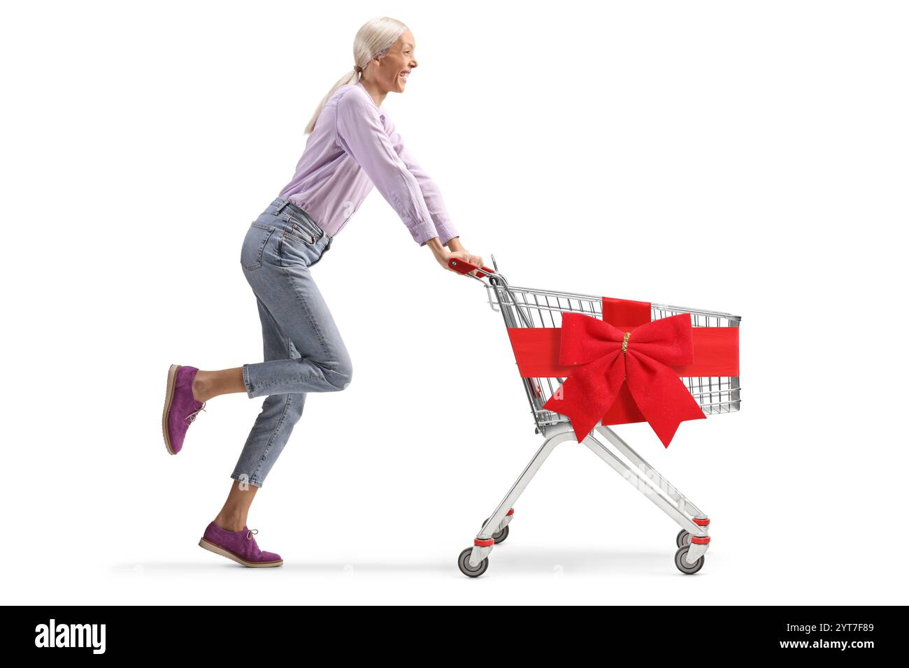 Tall slim woman running with a shopping cart tied with a red ribbon ...