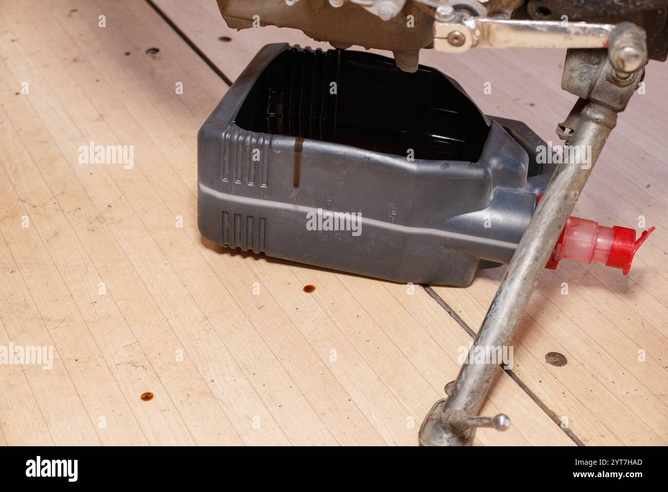 The process of draining oil from a motorcycle engine. Engine oil ...