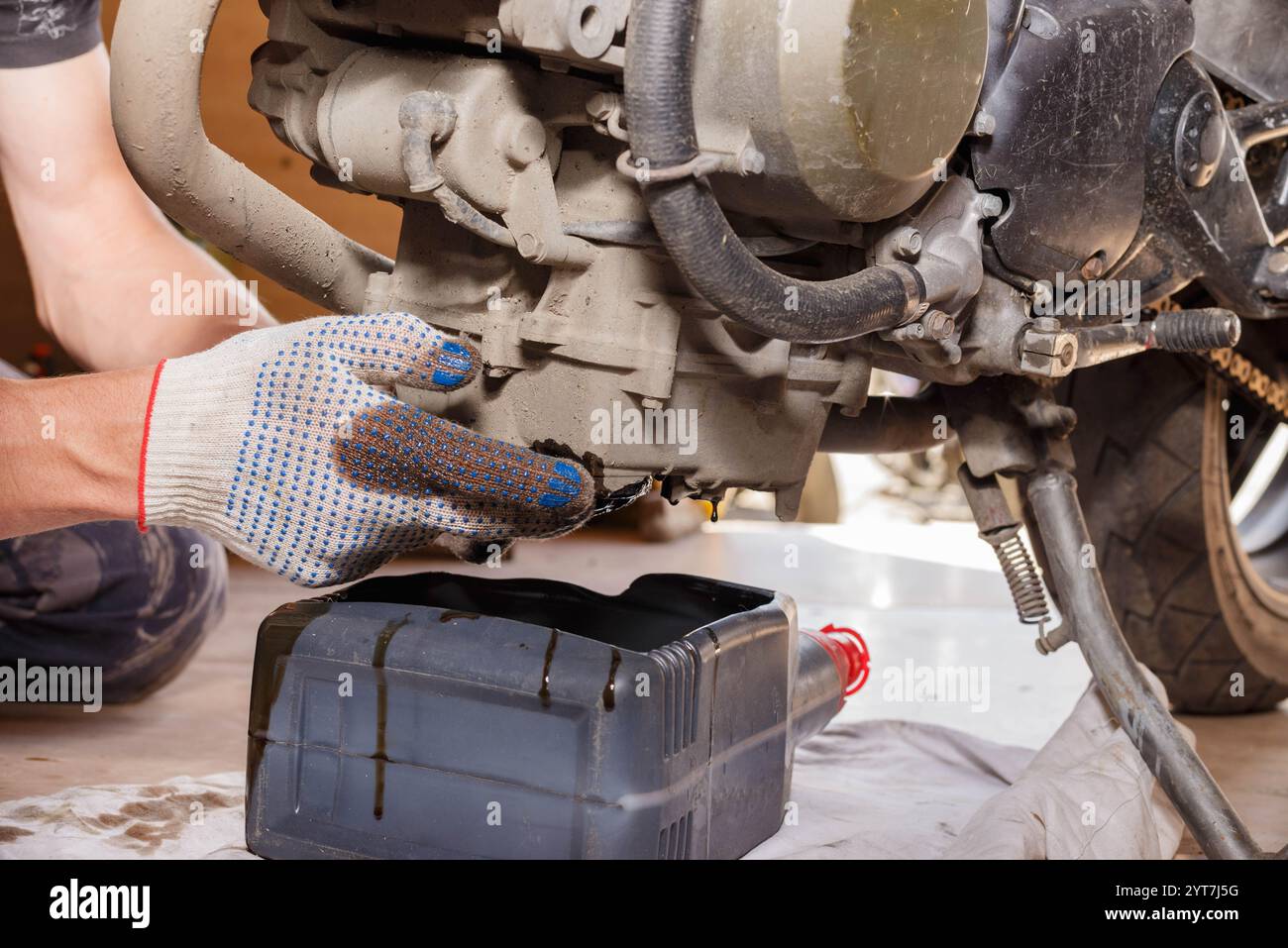 The process of draining oil from a motorcycle engine. Engine oil ...