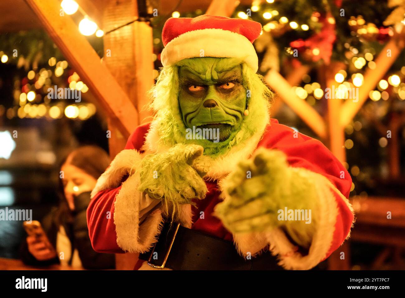 An actor dressed as the Grinch reacts at a Christmas funfair in Herne ...