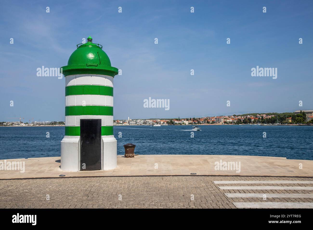 Small green and white lighthouse at the harbor. Beautiful building in ...