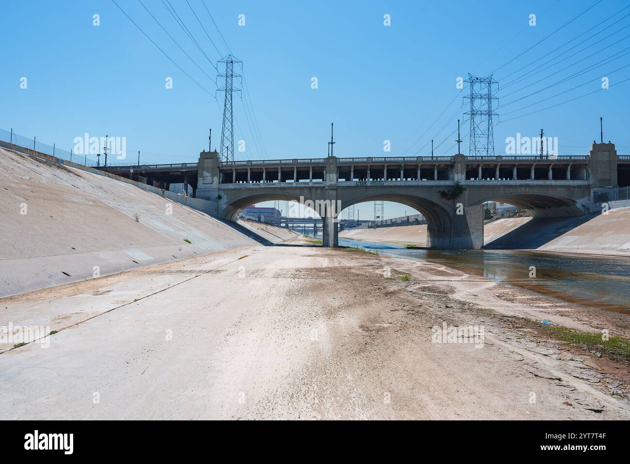 Concrete embankments and a bridge with arches span the Los Angeles ...