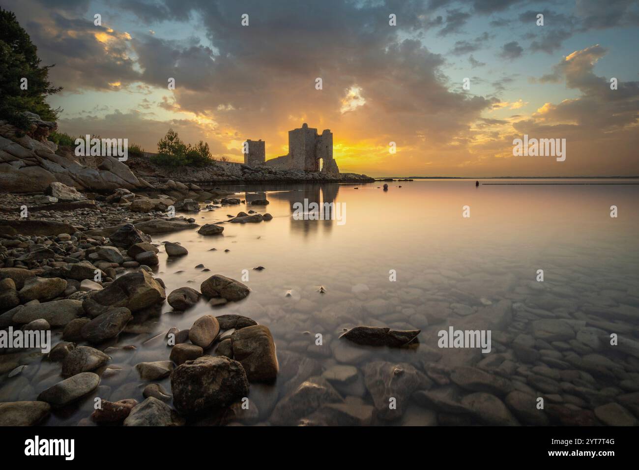 Castle ruins at dawn. Bay on the Mediterranean Sea with calm water at ...