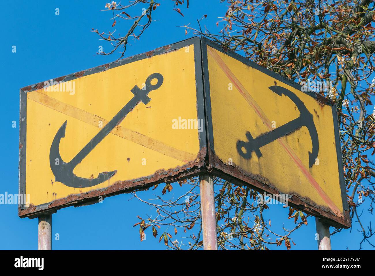Rusty yellow no-anchoring sign featuring black anchors, against a blue ...