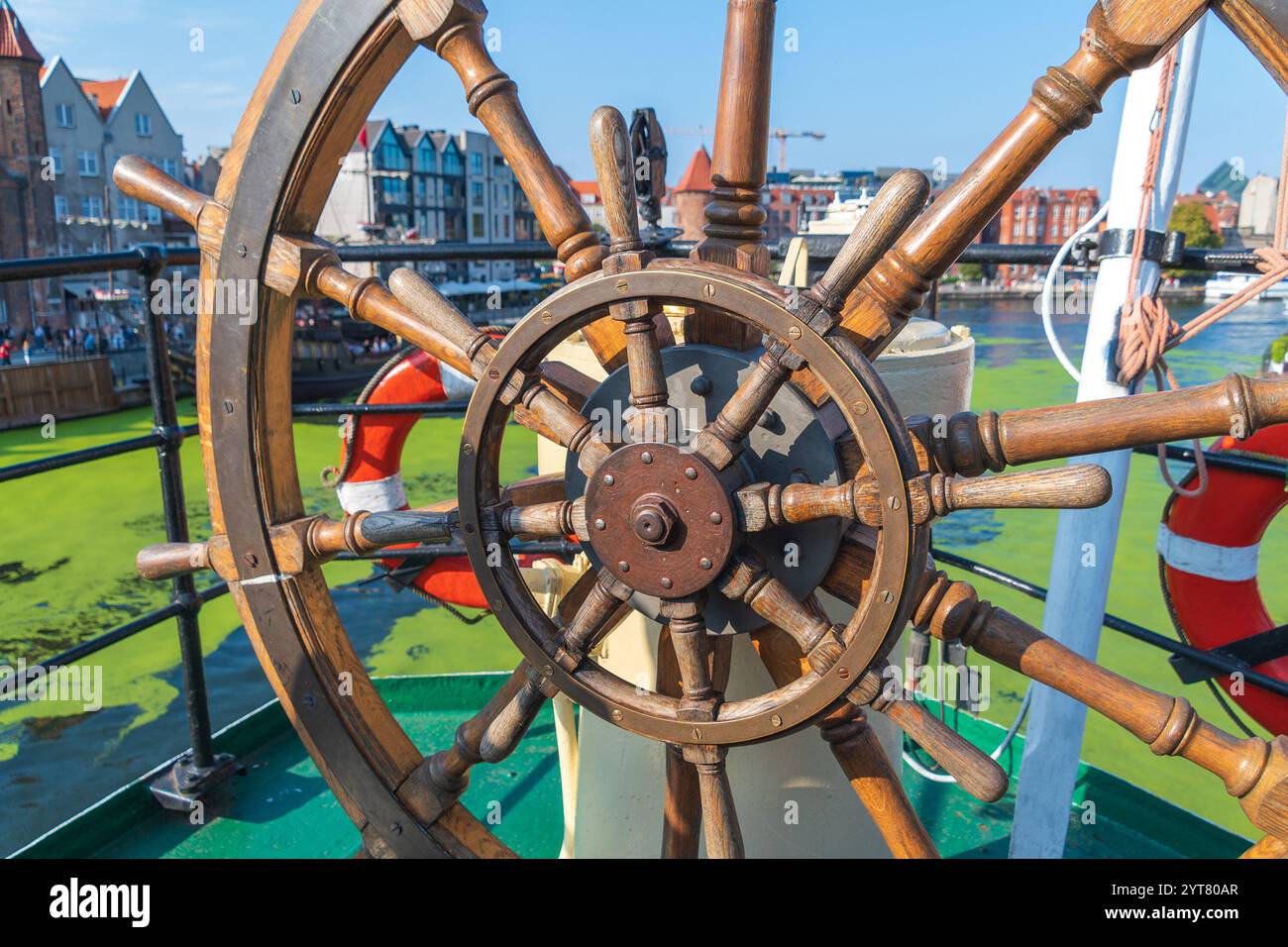 A close-up of a traditional wooden ship's wheel. Ship parts. An old sea ...