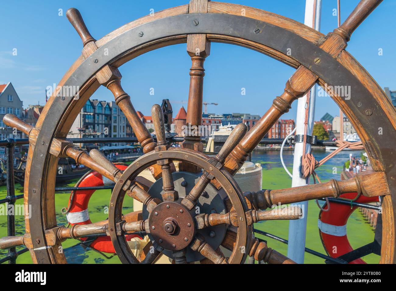 A close-up of a traditional wooden ship's wheel. Ship parts. An old sea ...