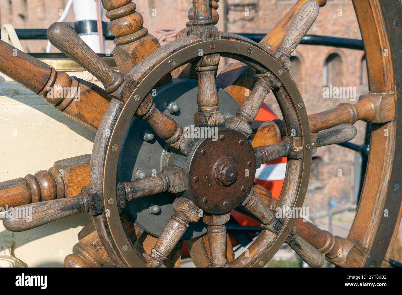 A close-up of a traditional wooden ship's wheel. Ship parts. An old sea ...