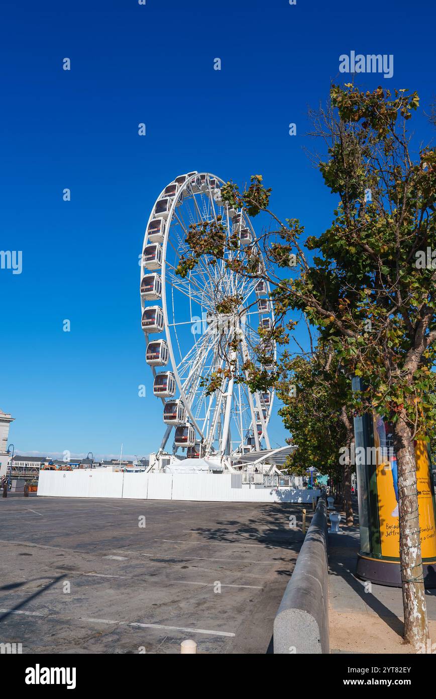 A large Ferris wheel stands against a clear blue sky at Pier 39, San ...
