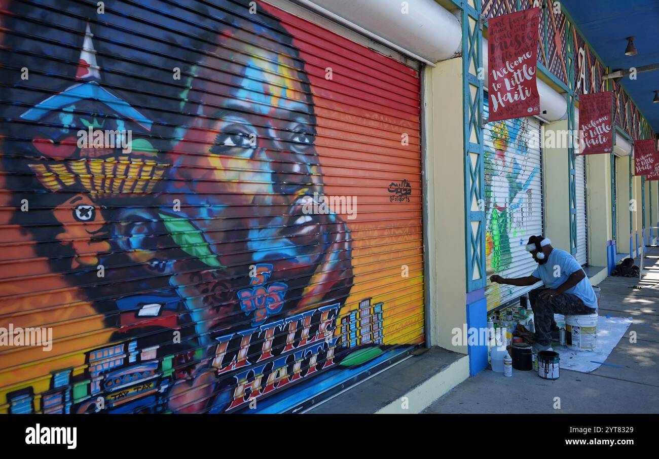 An artist known as Serge paints a mural outside of the Little Haiti Cultural Center during Miami ...
