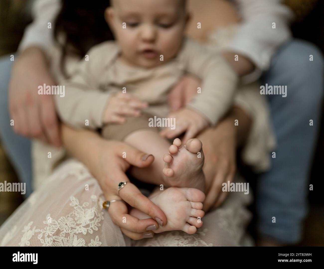 A child sits with its parents Stock Photo - Alamy