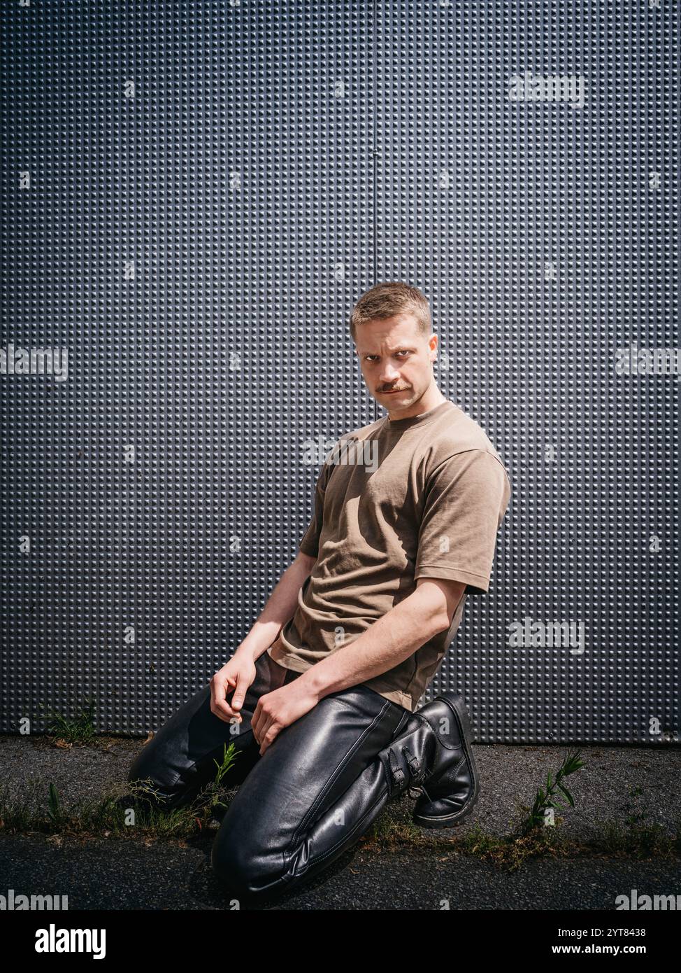 Man kneeling in front of wall outdoors Stock Photo - Alamy