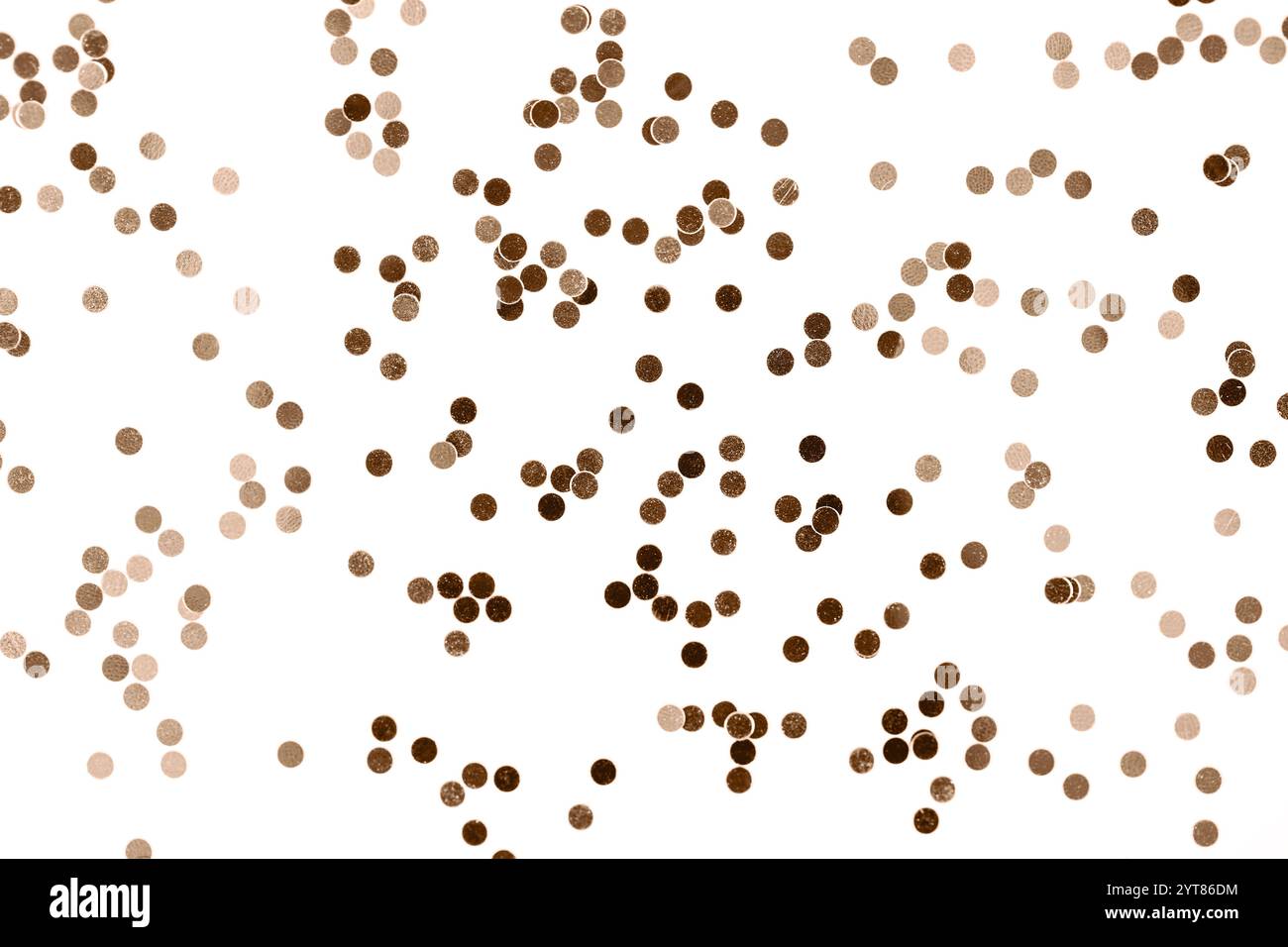 Brown confetti scattered on a white background for festive celebrations ...