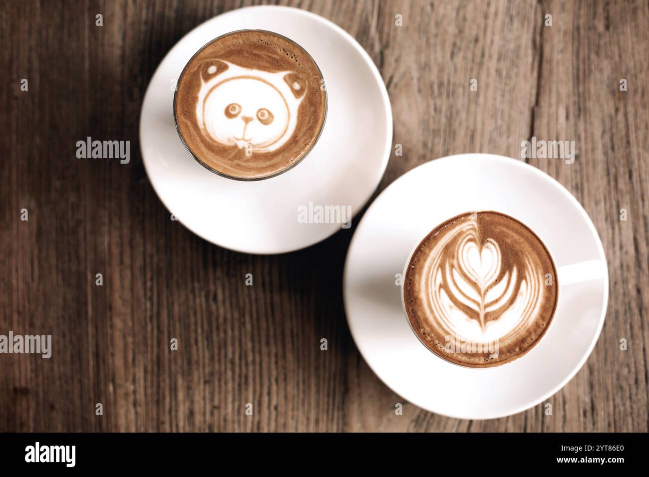 Latte art featuring a panda and leaf design on wooden table surface ...