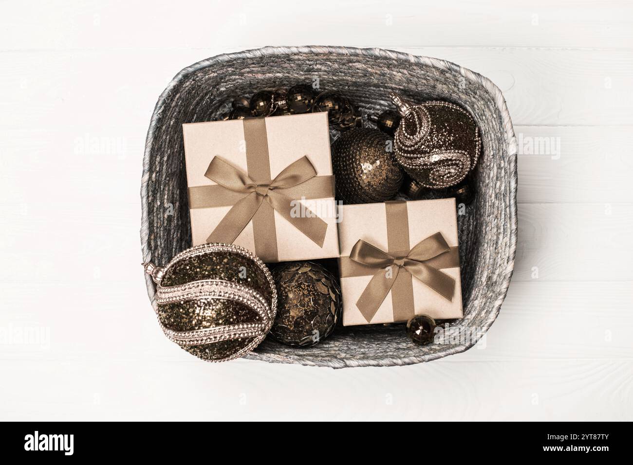Elegant holiday gift boxes with bronze decorations in a woven basket ...