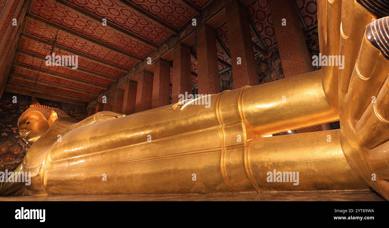View of the large statue of the Reclining Buddha in Wat Pho (Temple of The Reclining Buddha) in ...