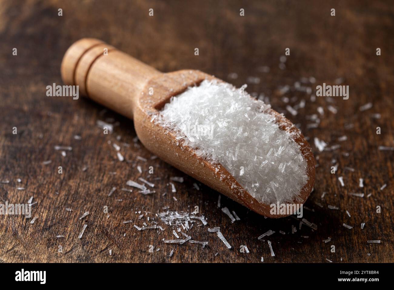 MSG white crystals n a wooden scoop macro. Scoop full of monosodium ...