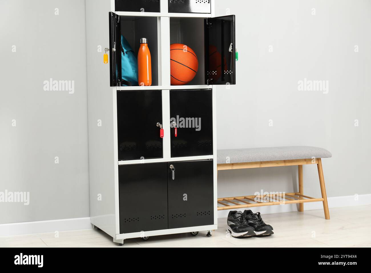 Lockers with personal belongings and bench in changing room at gym ...