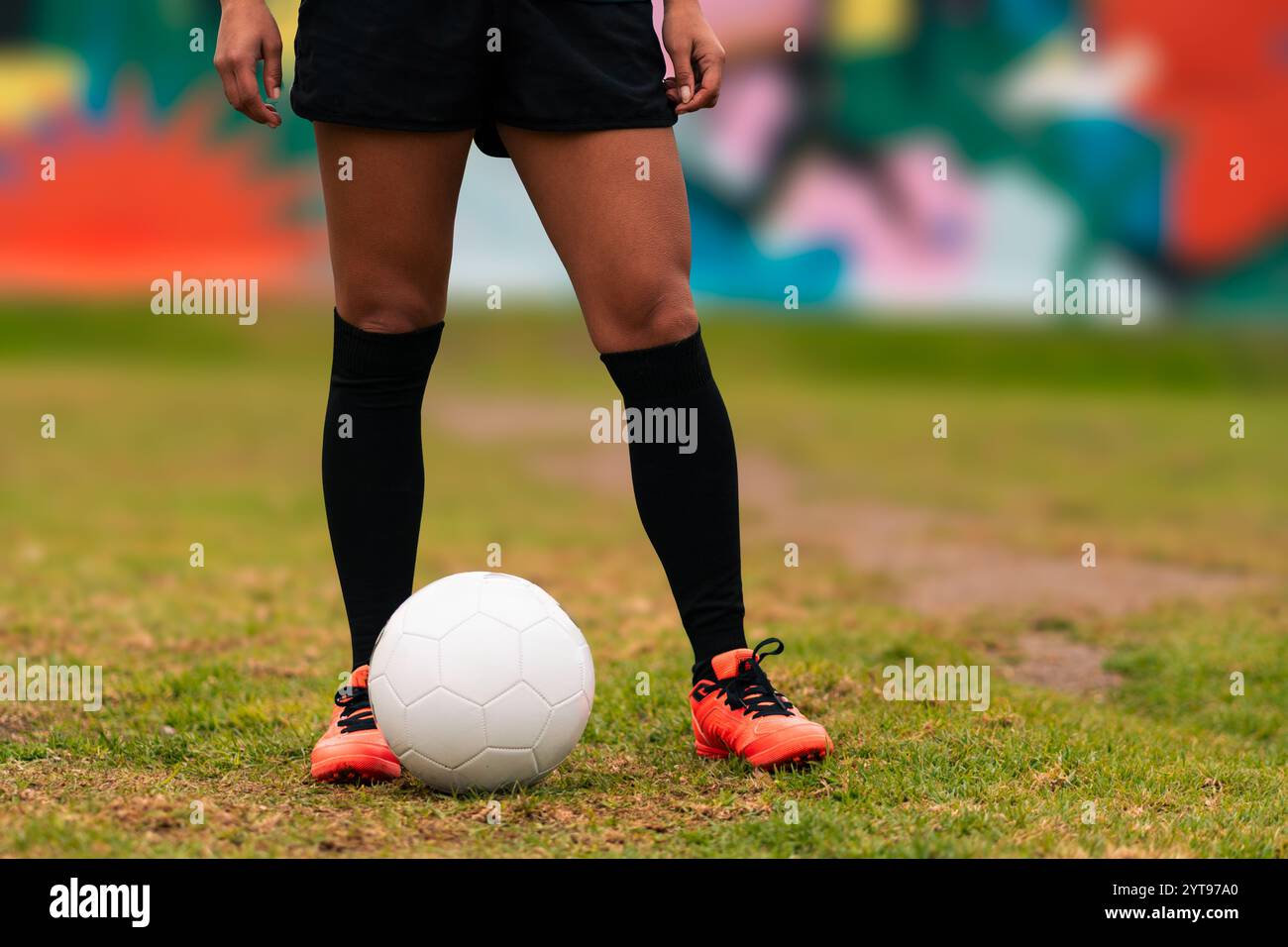 View of legs of brunette female soccer player running to kick soccer ...