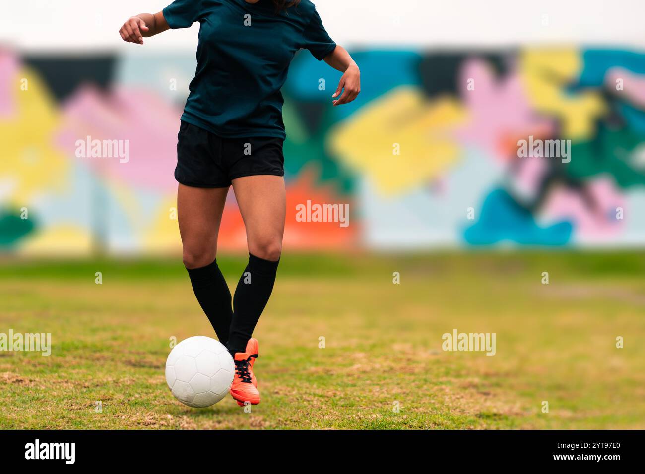 View of legs of brunette female soccer player running to kick soccer ...
