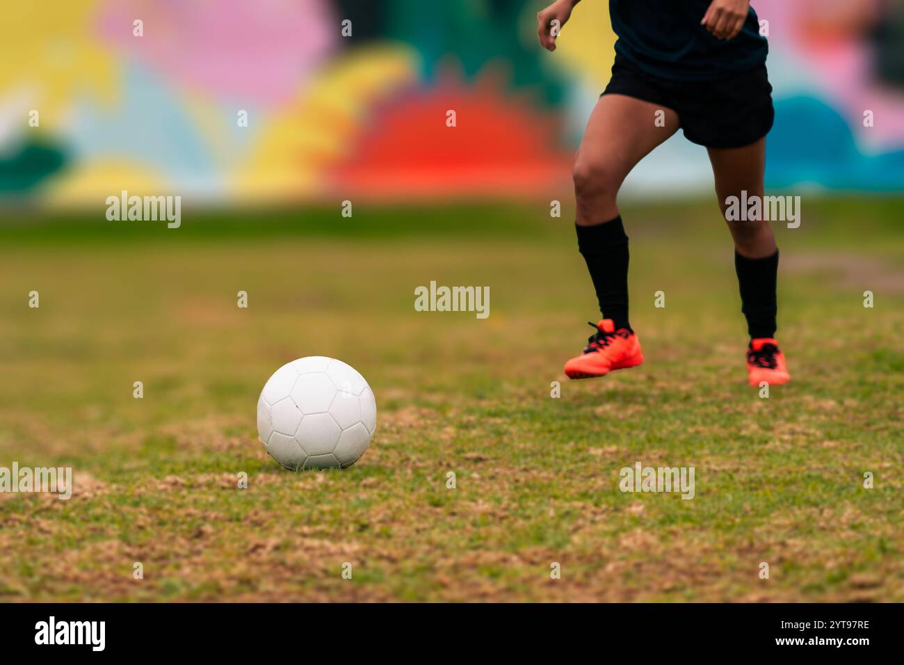 View of legs of brunette female soccer player running to kick soccer ...