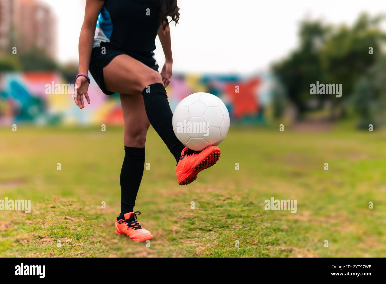 View of legs of brunette female soccer player running to kick soccer ...