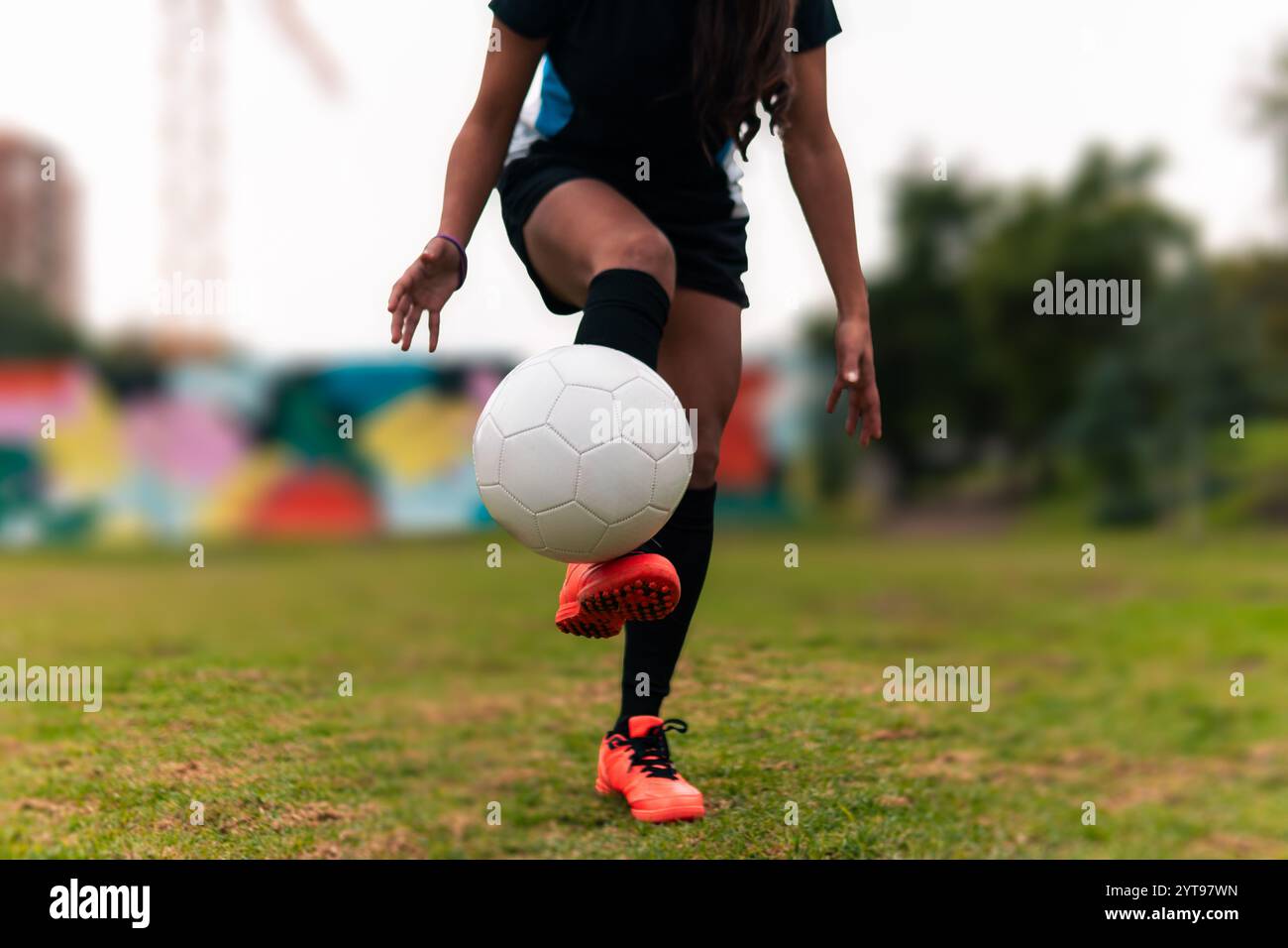 View of legs of brunette female soccer player running to kick soccer ...