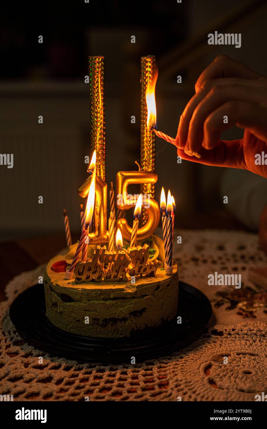 light candles for 15 years with gold numbers on pistachio cake ...