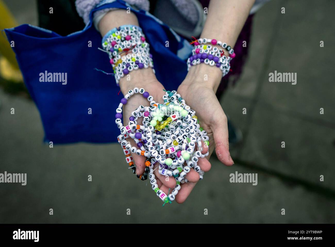 A fan poses in front of an inflatable friendship bracelet before the ...