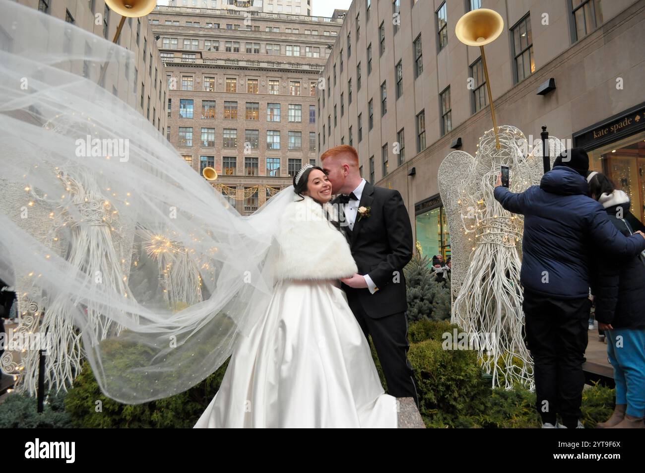 A bride and groom kiss in Rockfeller Center in Manhattan, New York City ...