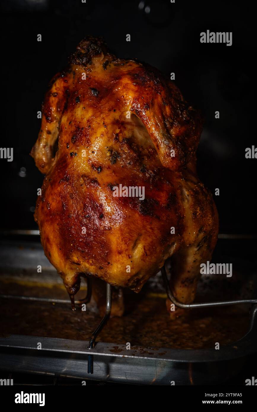 Whole chicken roasted inside oven on chicken stand up stainless stand ...
