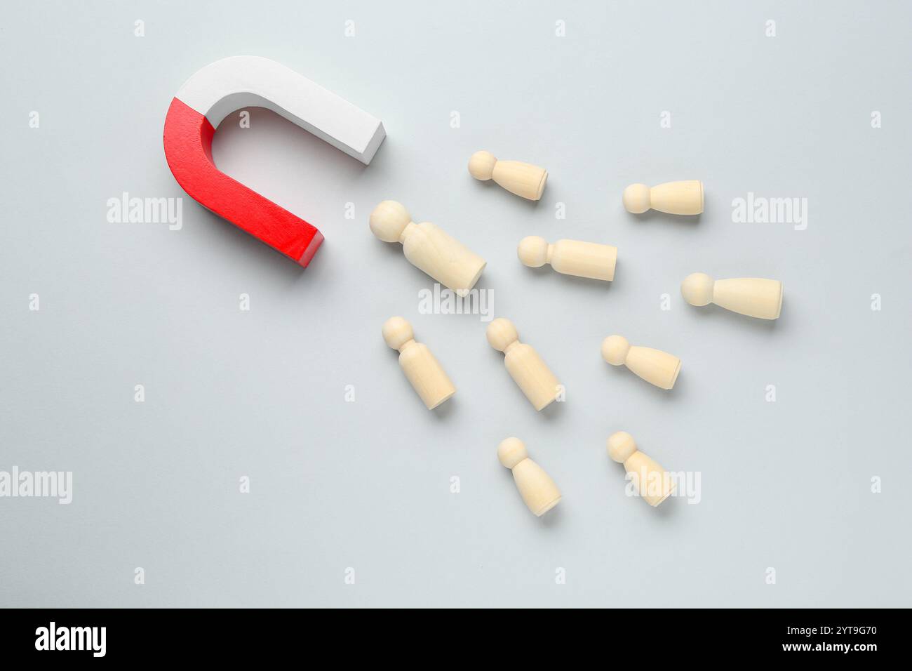 Magnet attracting human figures on light grey background, flat lay ...