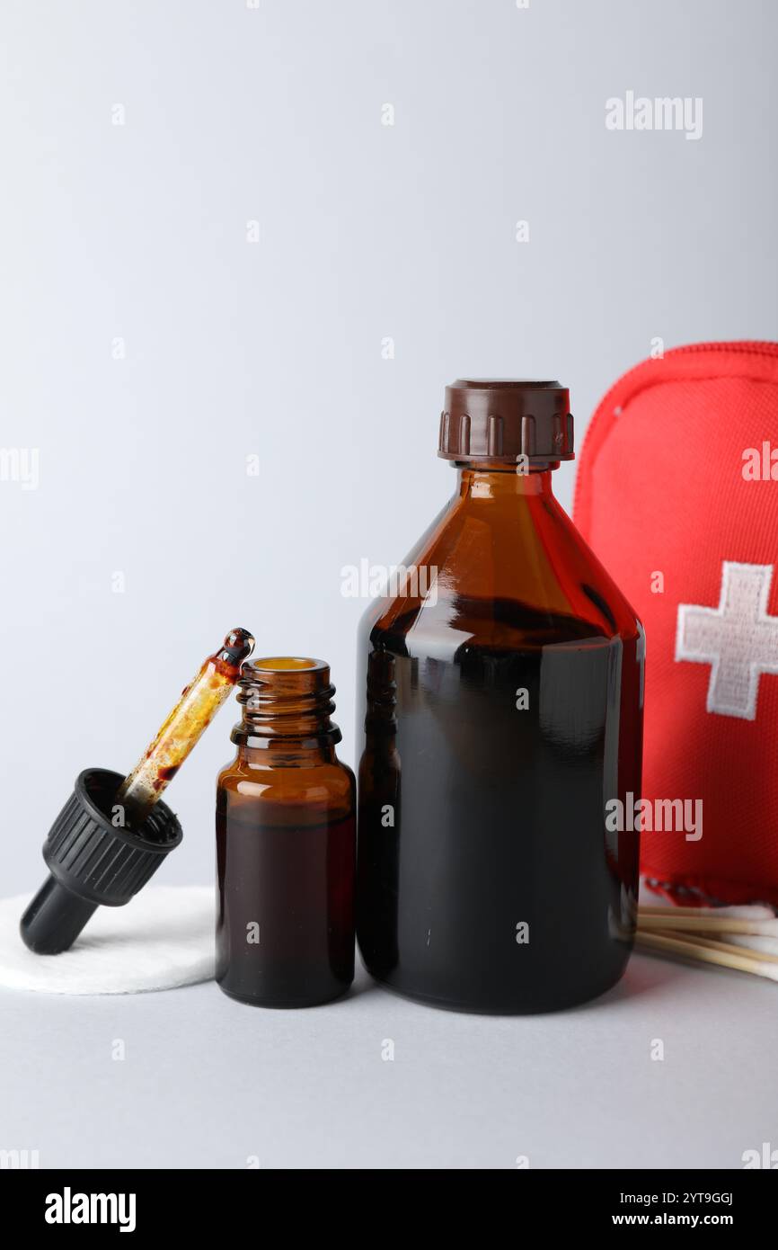 Topical iodine and other first aid kit components on light background ...
