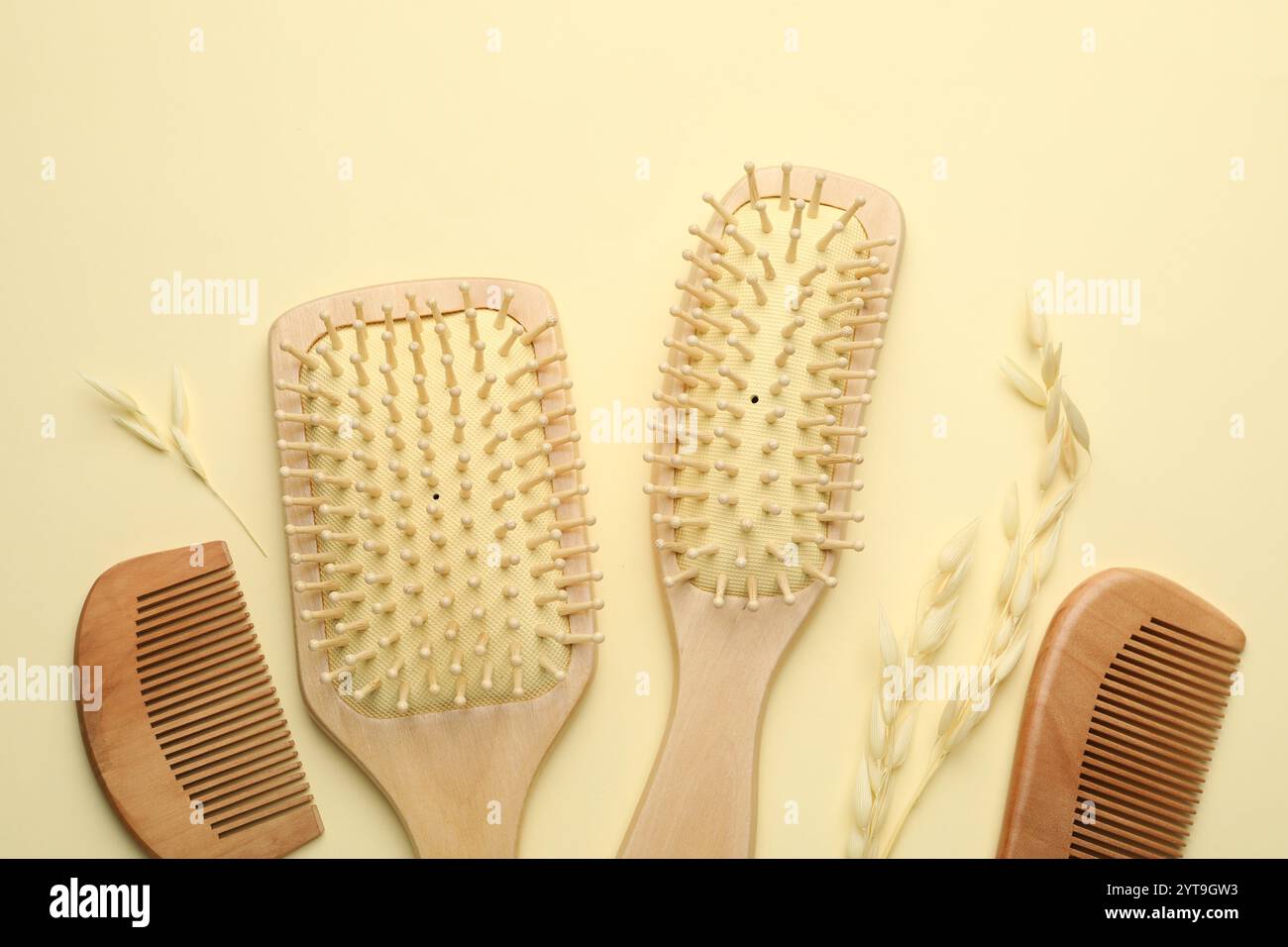 Wooden hair brushes, combs and spikes on beige background, flat lay ...