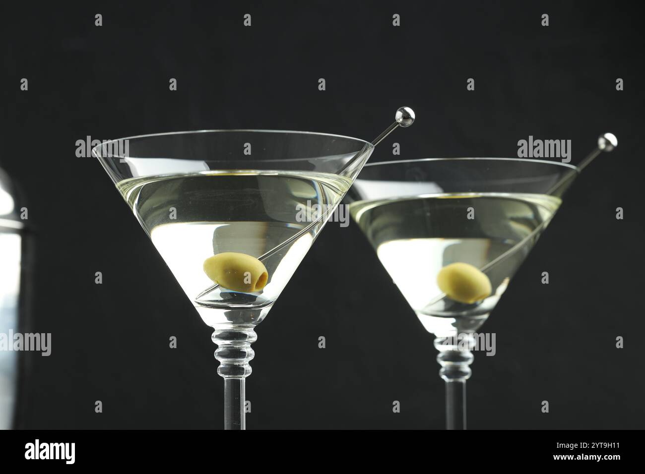 Martini cocktail with olives in glasses on black background, closeup ...