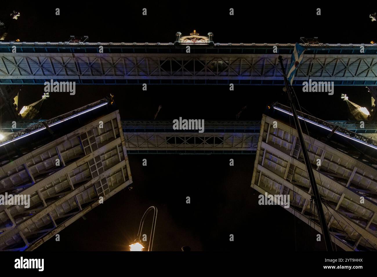 Passing under Tower Bridge, London at night with the road section ...