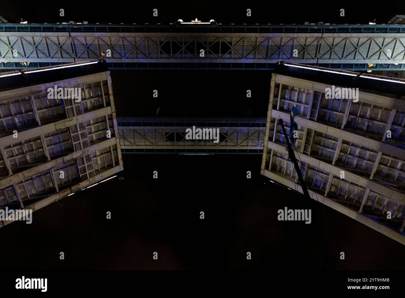 Passing under Tower Bridge, London at night with the road section ...