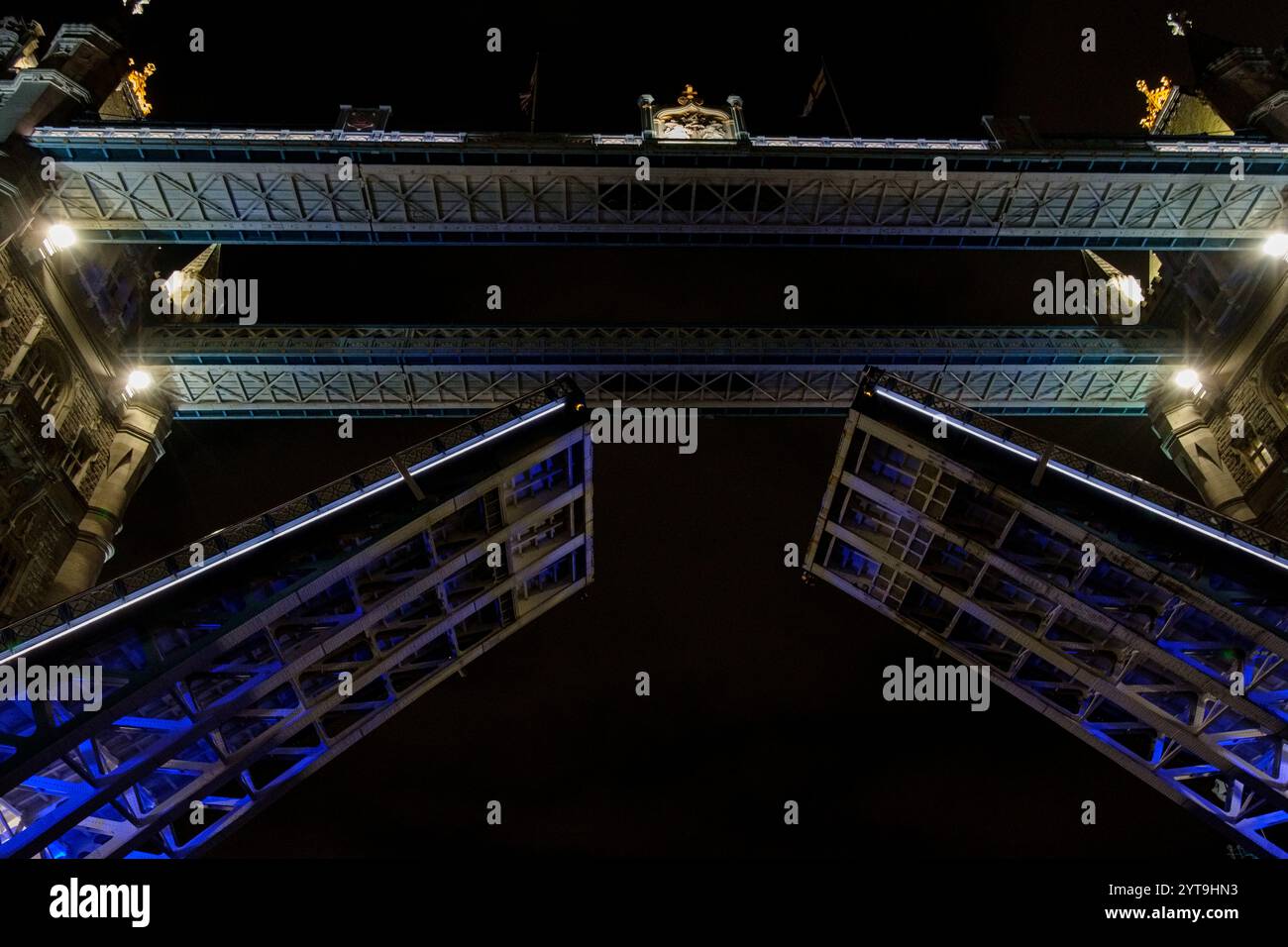 Passing under Tower Bridge, London at night with the road section ...