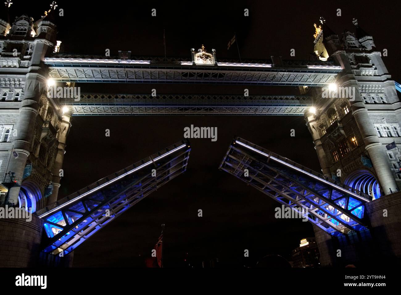 Passing under Tower Bridge, London at night with the road section ...
