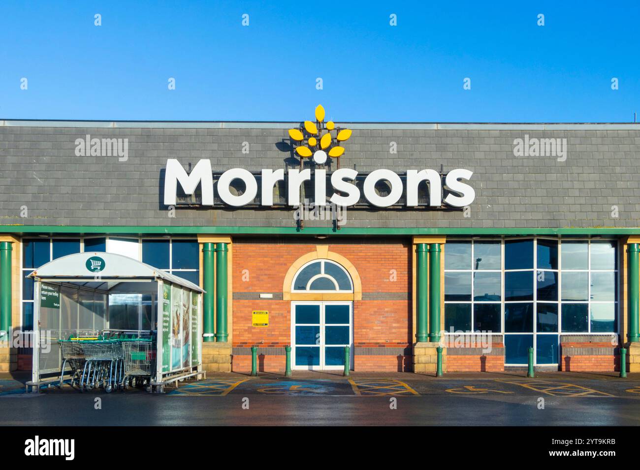 Front view of a Morrisons supermarket sign against a clear blue sky ...