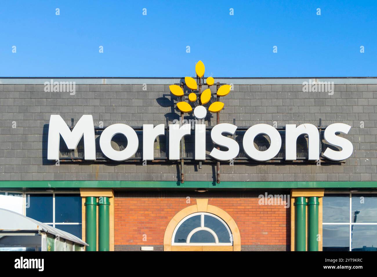 Front view of a Morrisons supermarket sign against a clear blue sky ...