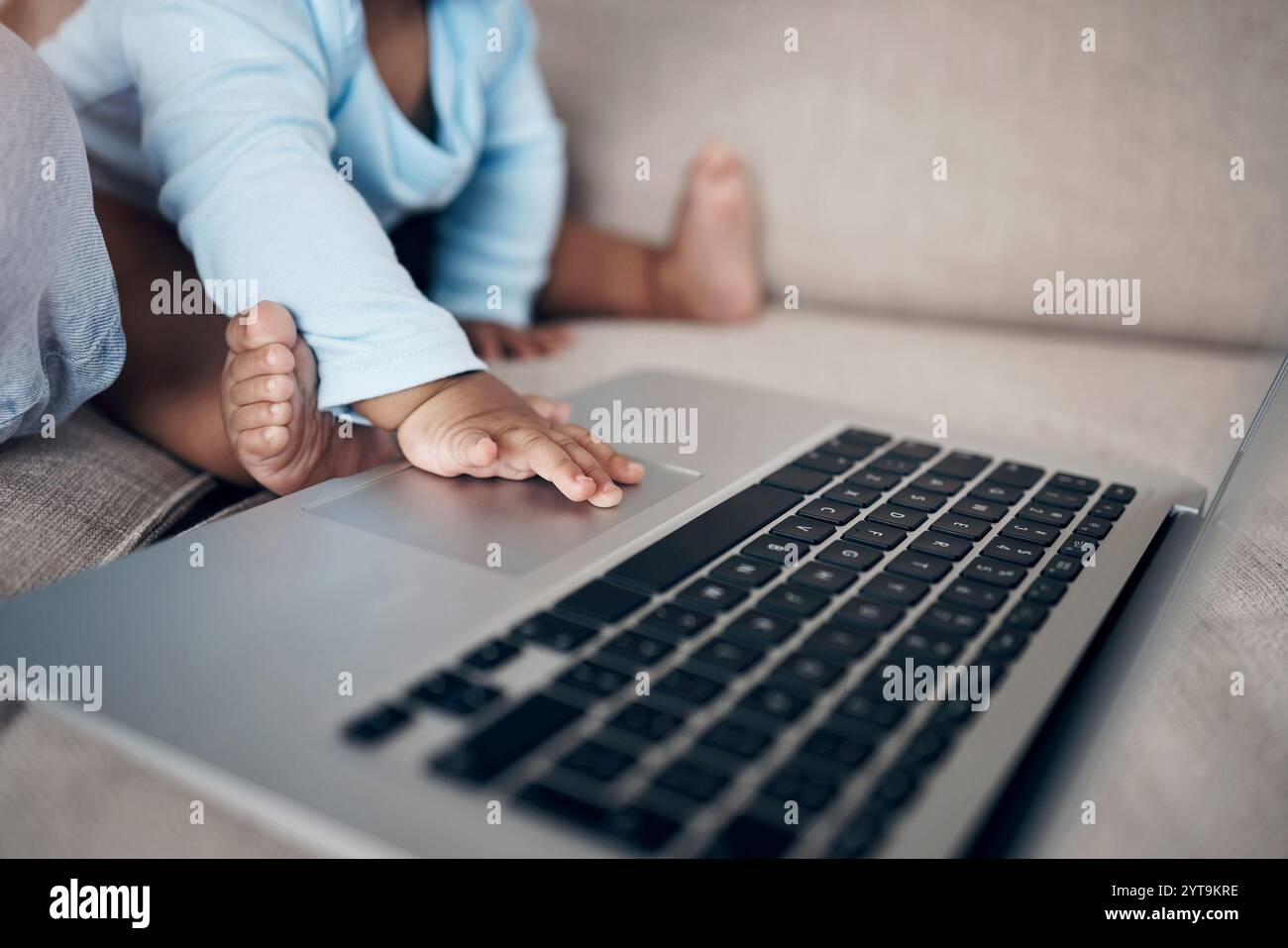 Parent, hands and baby with laptop in home, playing and sensory touch ...