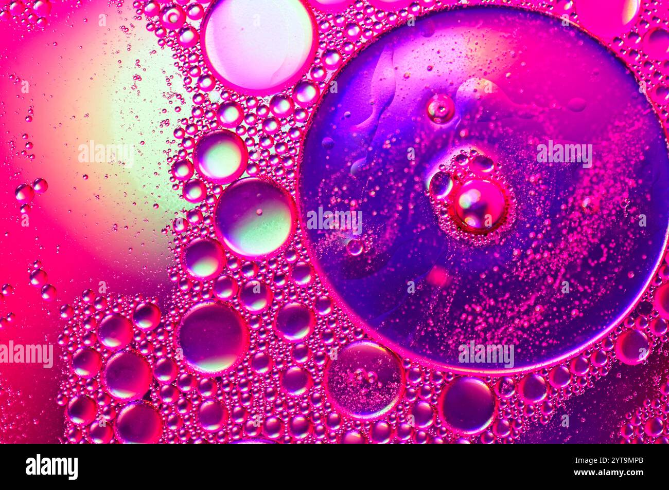Circular shapes of oil in water with pink highlights Stock Photo - Alamy