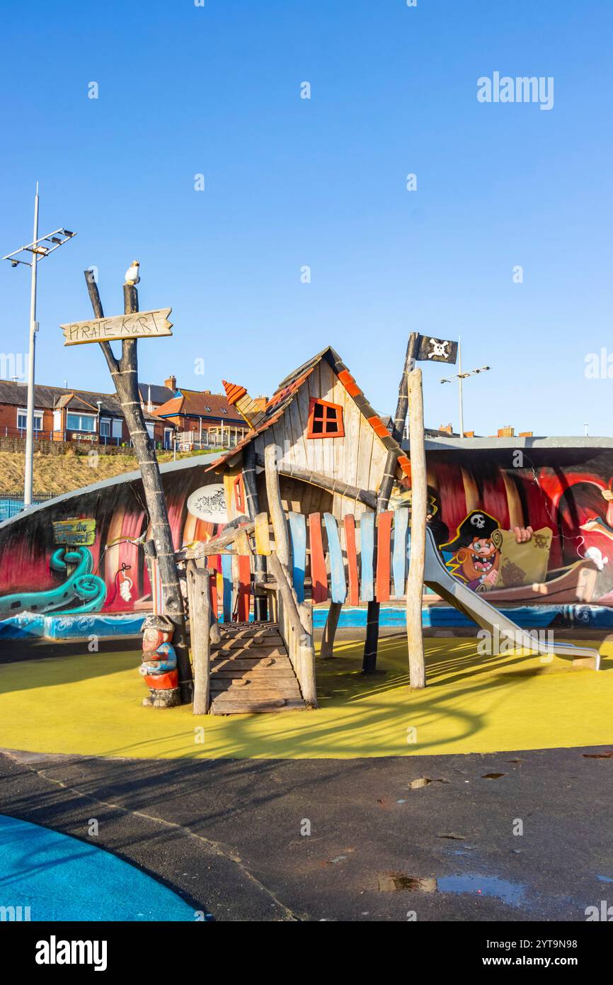 Wooden pirate-themed playground structure with a slide surrounded by ...