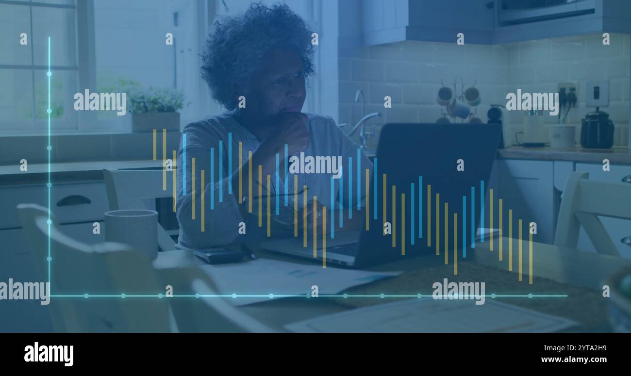 Analyzing data on laptop, woman with financial graph image over kitchen ...