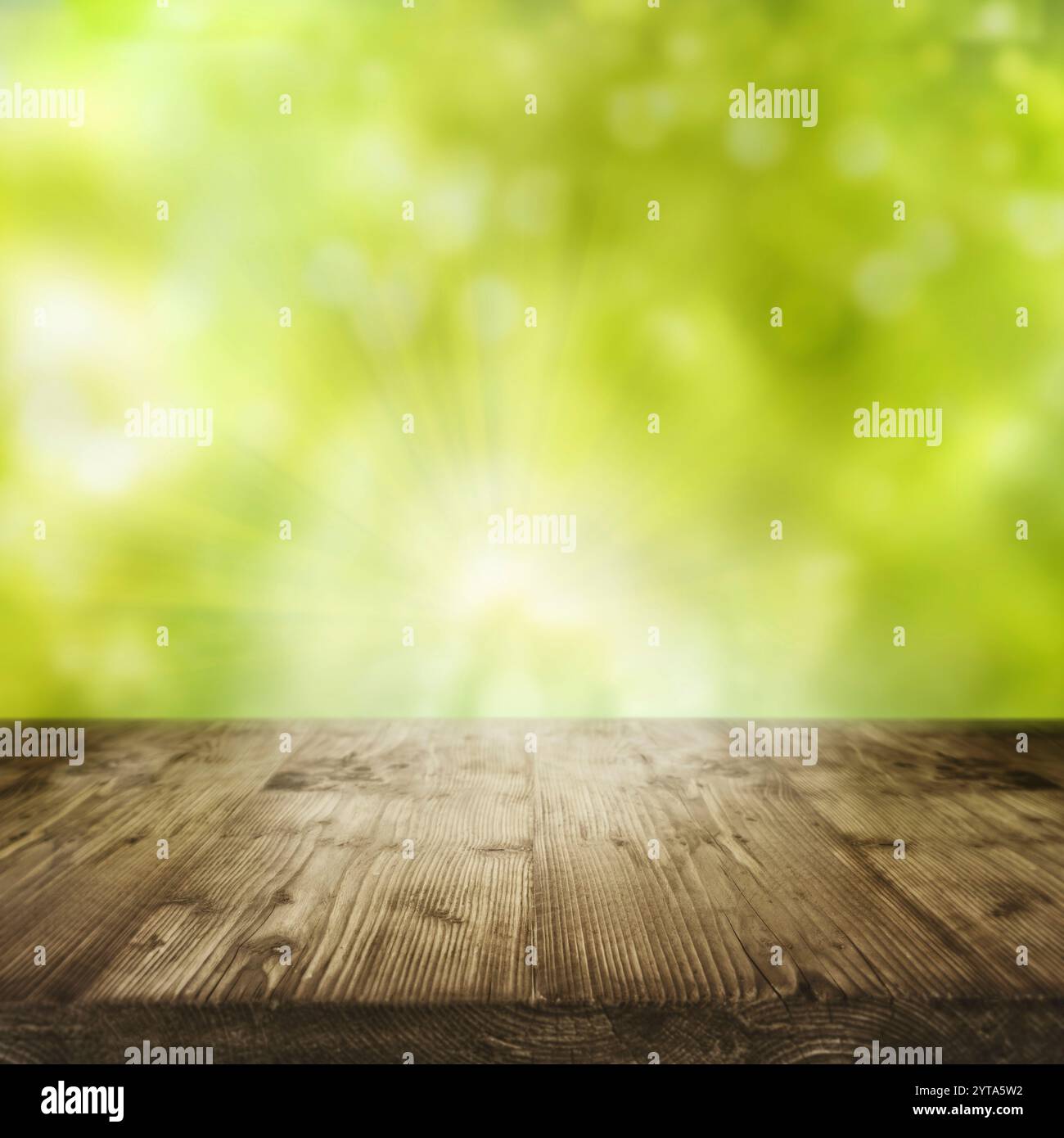 Fresh green spring background in front of an old rustic wooden table ...