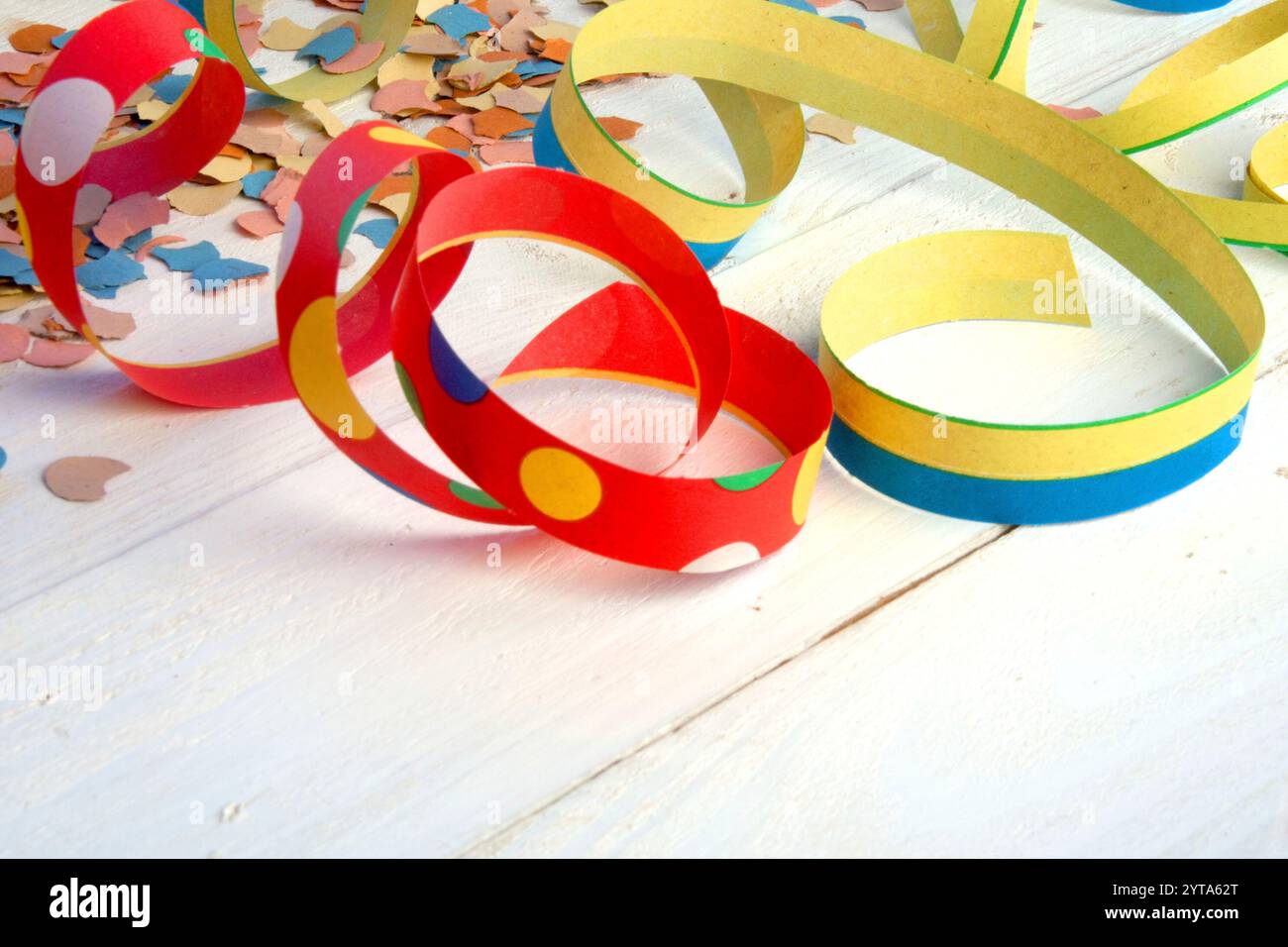 Colorful streamers and confetti on a white wooden table for a carnival ...